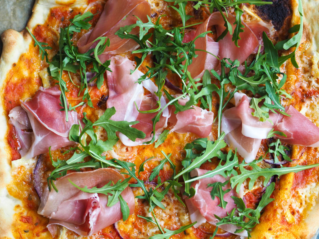 Ta pizzaen ut av ovnen og fordel spekeskinke over. Jeg liker også å ha ...