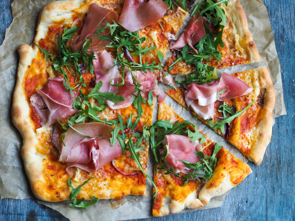 Ta pizzaen ut av ovnen og fordel spekeskinke over. Jeg liker også å ha ...